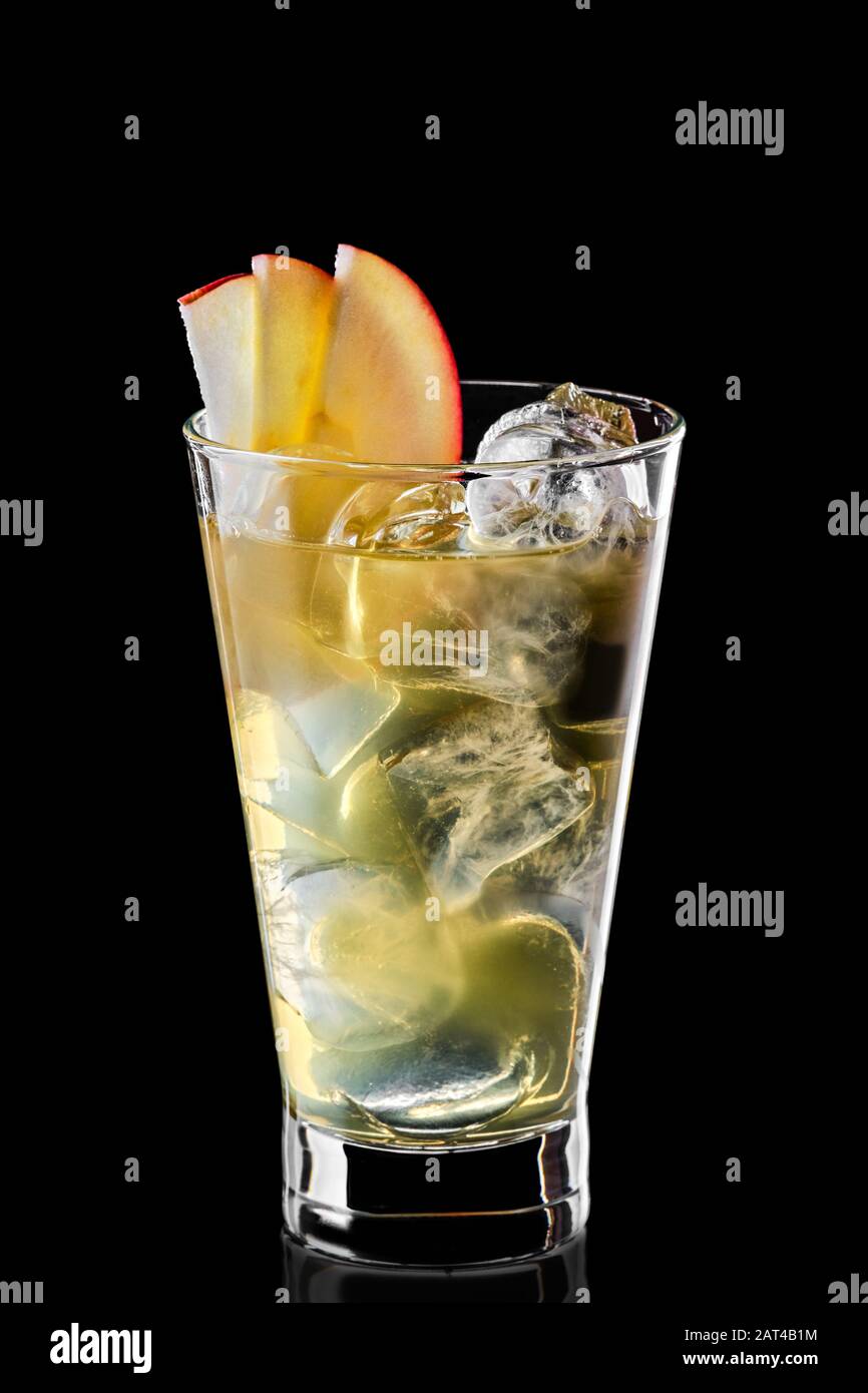 Glass of cold water with ice cubes and apple syrup isolated on black ...