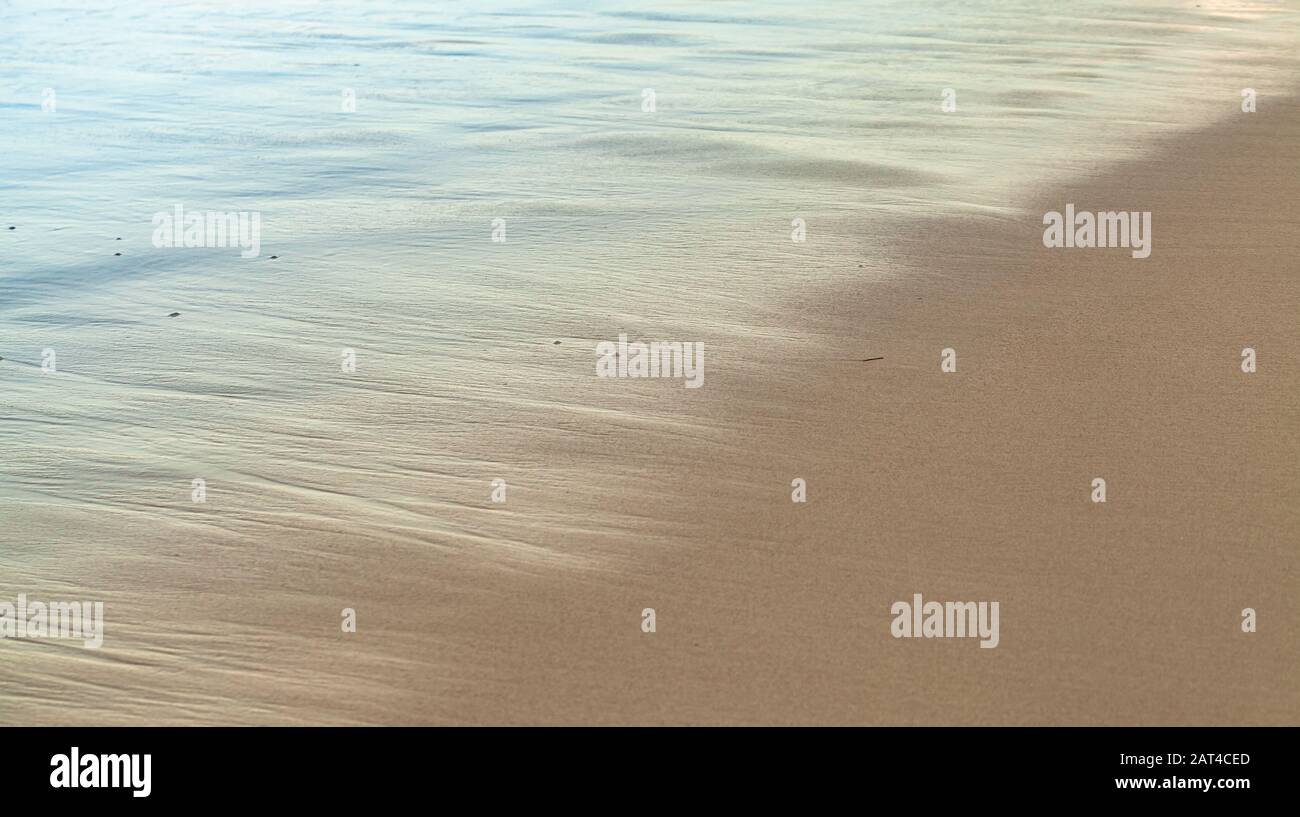 Wet shiny coastal sand and sea water, abstract natural background photo ...