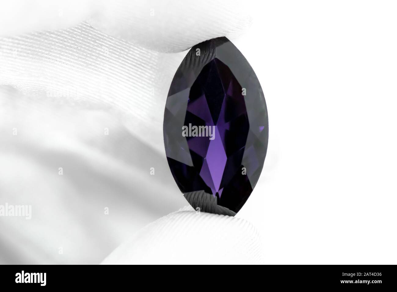 Hand with white gloves holding purple amethyst gemstone in white ...