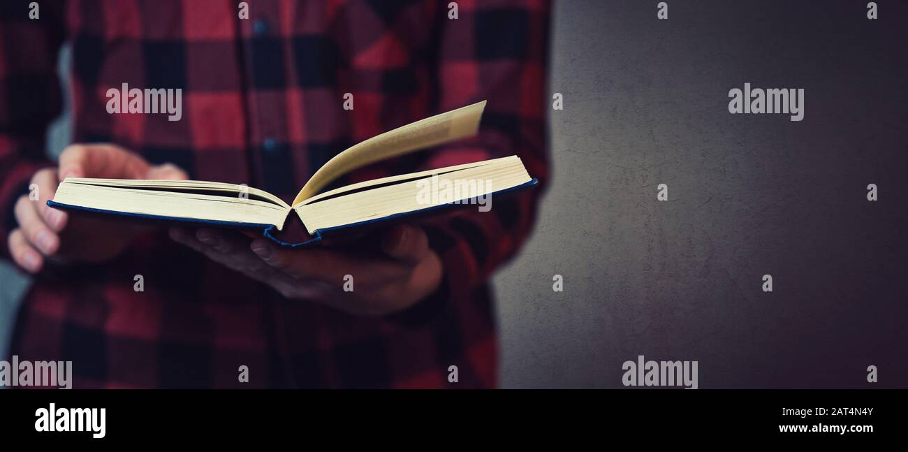 Close up of reader hands holding an open book finding information ...
