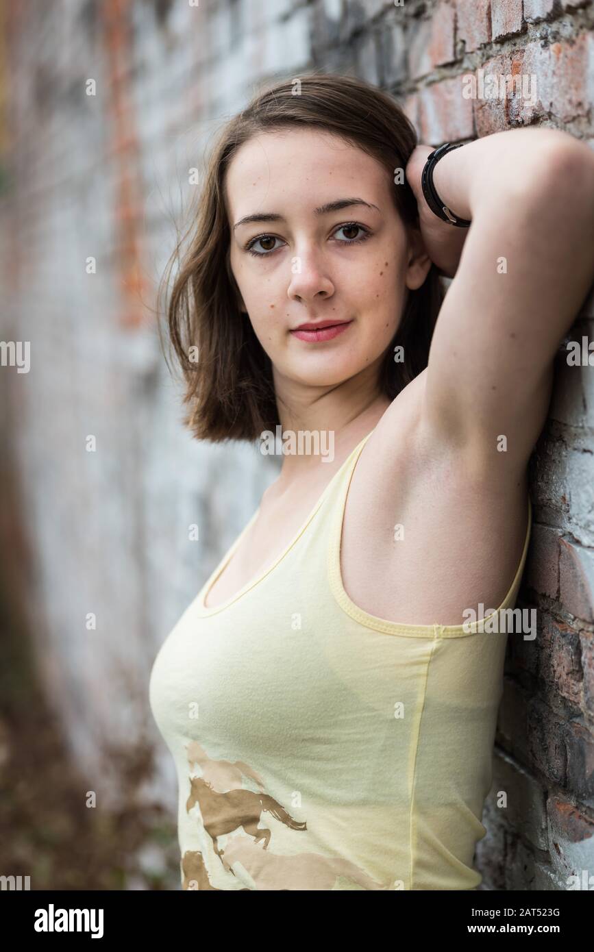 portrait-of-a-busty-17-year-old-college-girl-posing-against-a-rough