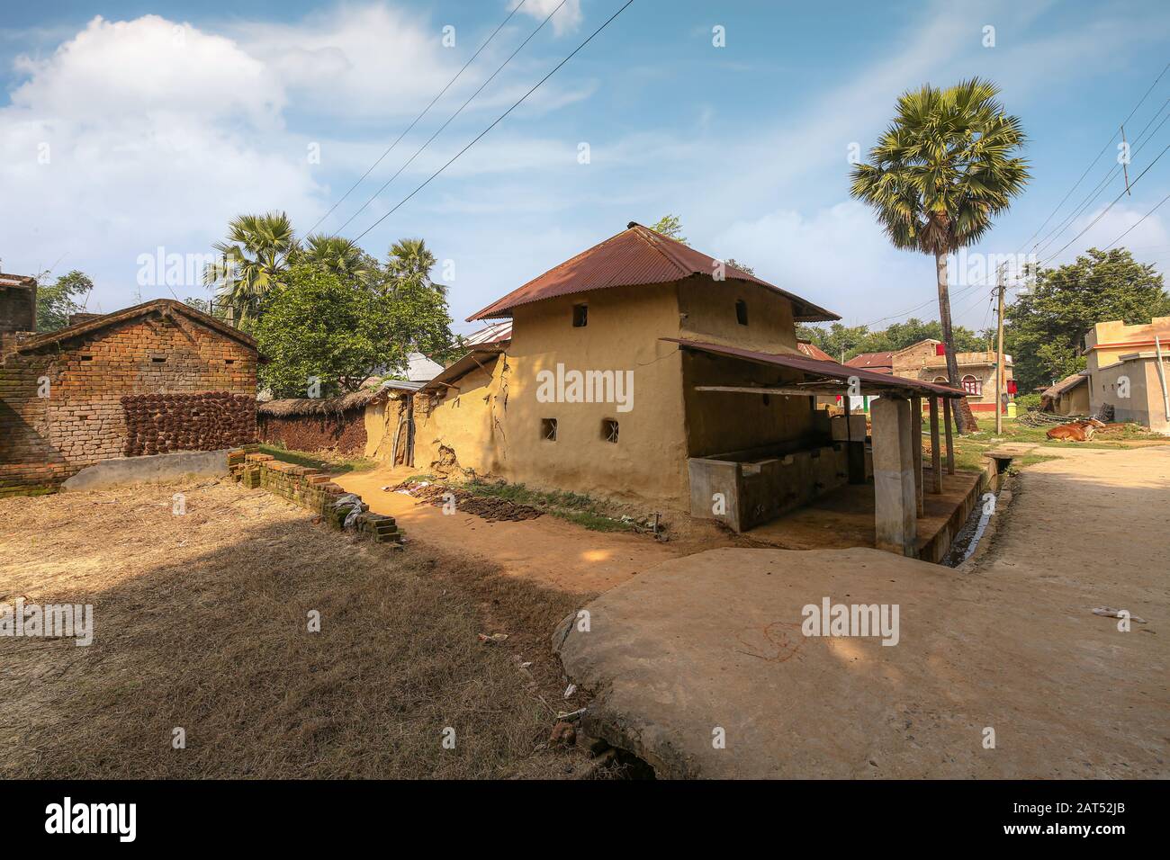 Indian village scene with view of mud houses and unpaved village road ...