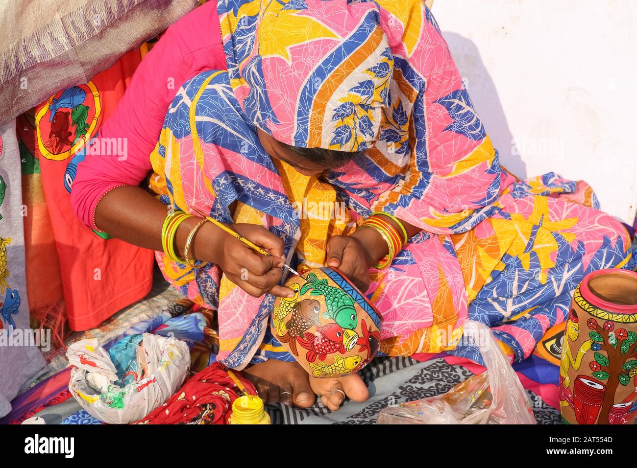 Indian woman artist worker doing fabric painting with brush on a craft ...