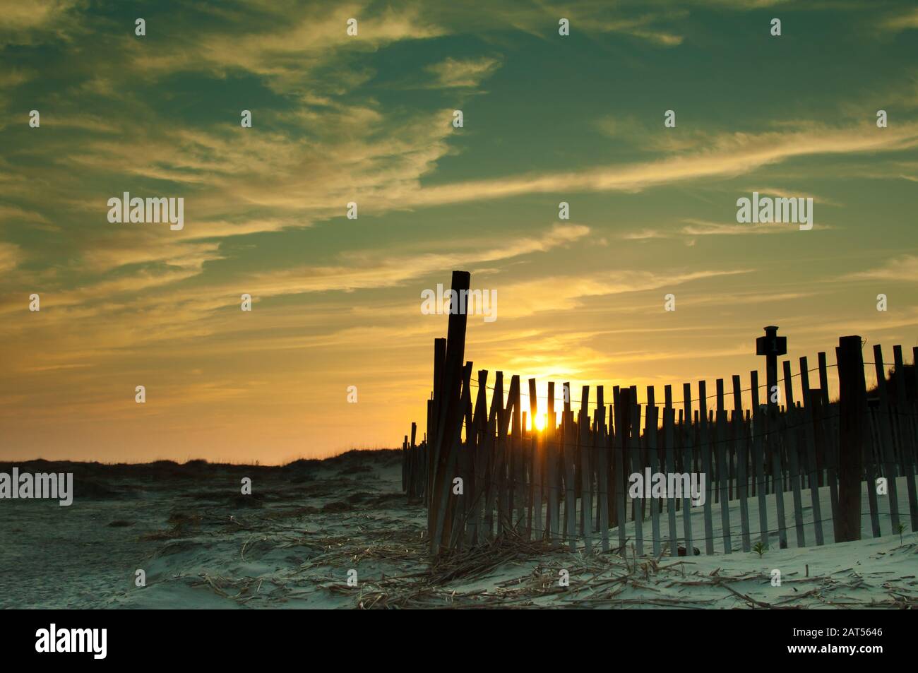 Silhouettes of fences on the beach under the sunlight during a ...