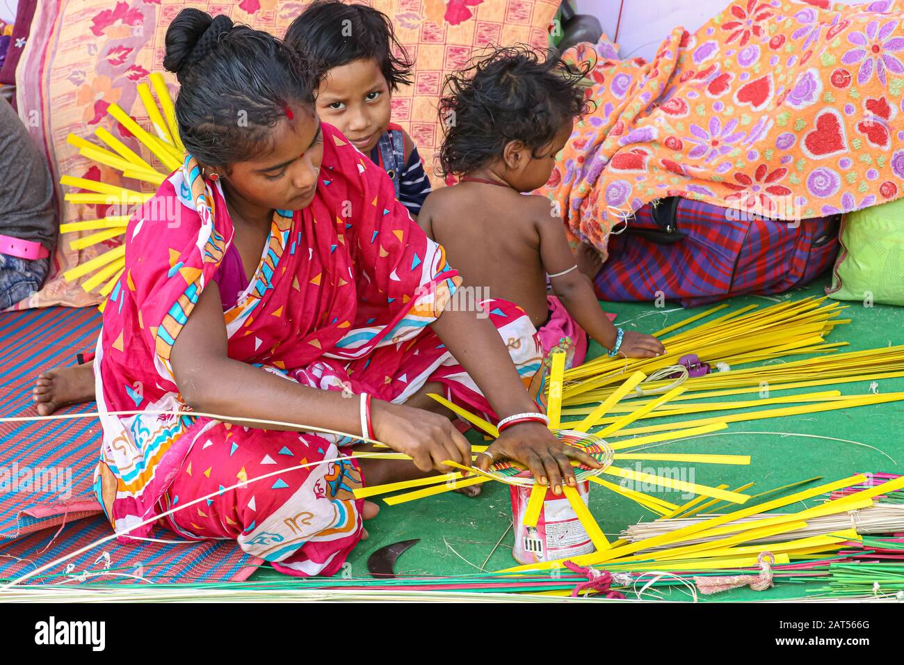 Rural woman hand weaving a basket from bamboo cane strands at a ...