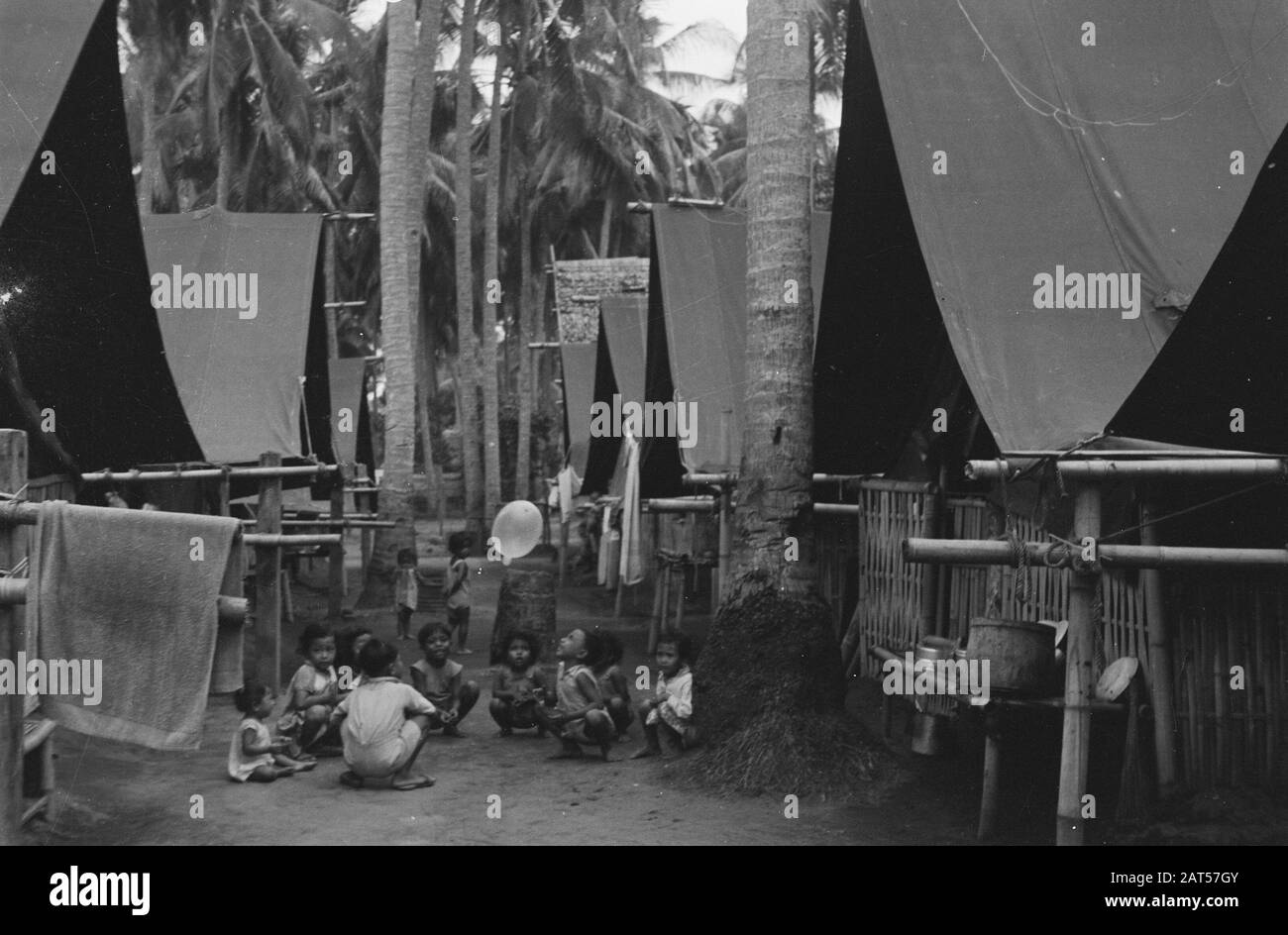 Paré-Paré (Celebes) Children sit in a circle between houses in a ...