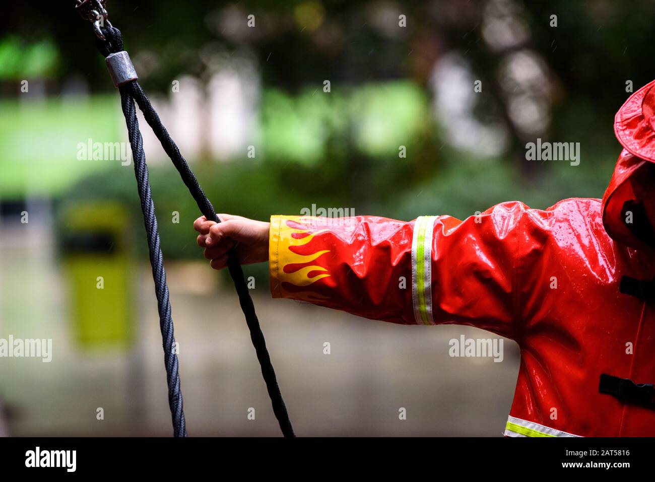 Detail of the hand of a child firefighter clutched with his arm ...