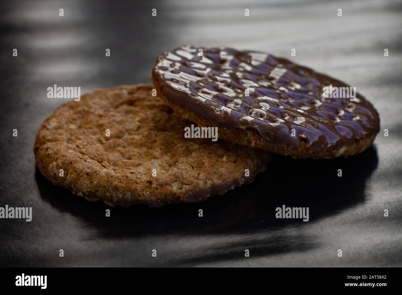 Two milk chocolate biscuits one on top of the other looking delicious ...