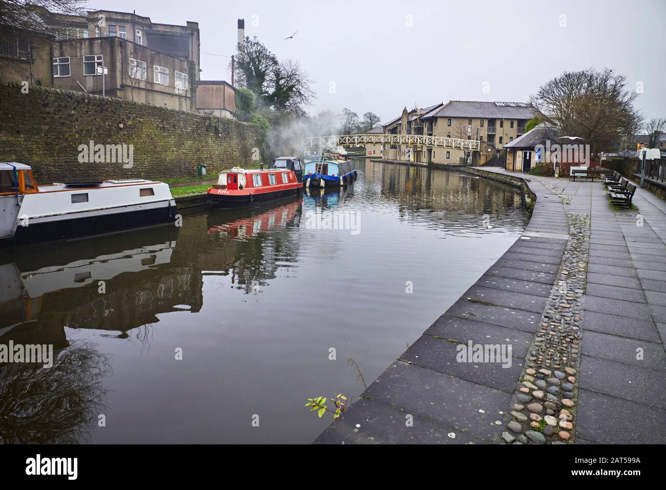 Canal at Lancaster with wide and narrow beam boats on winter moorings ...