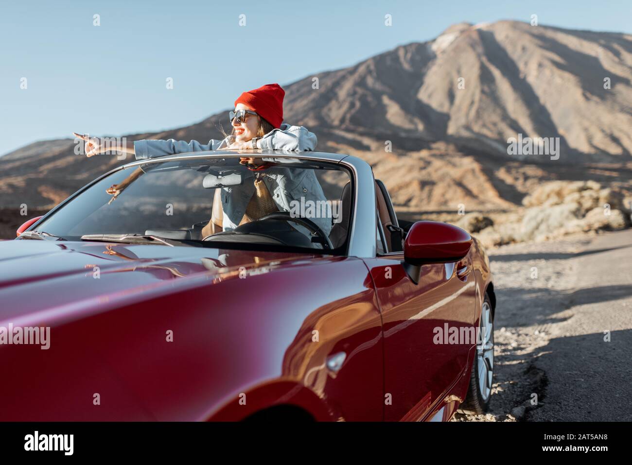 Lifestyle portrait of a young woman enjoying road trip on the desert ...