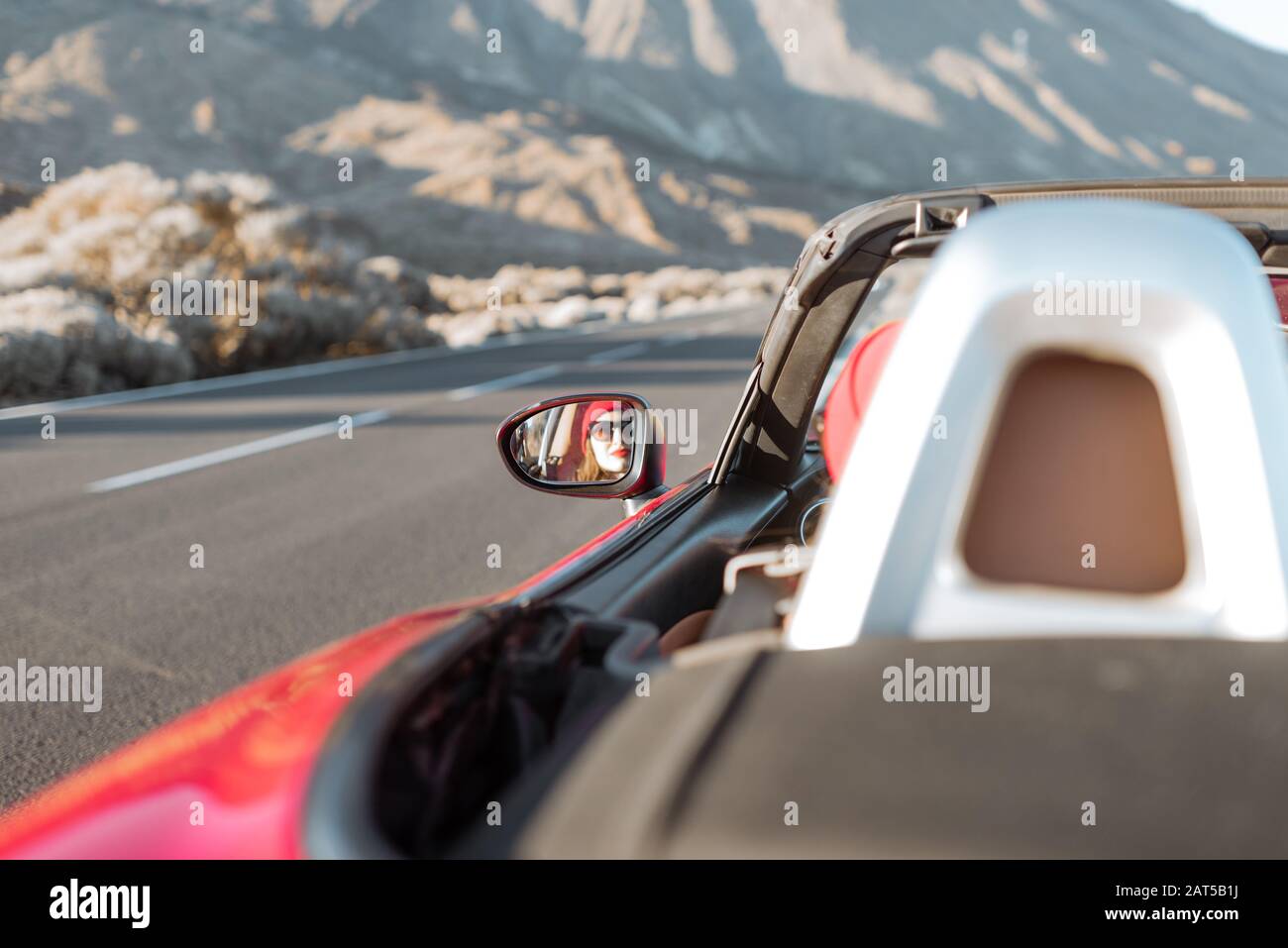 Woman driving convertible car on the beautiful desert road, view from ...
