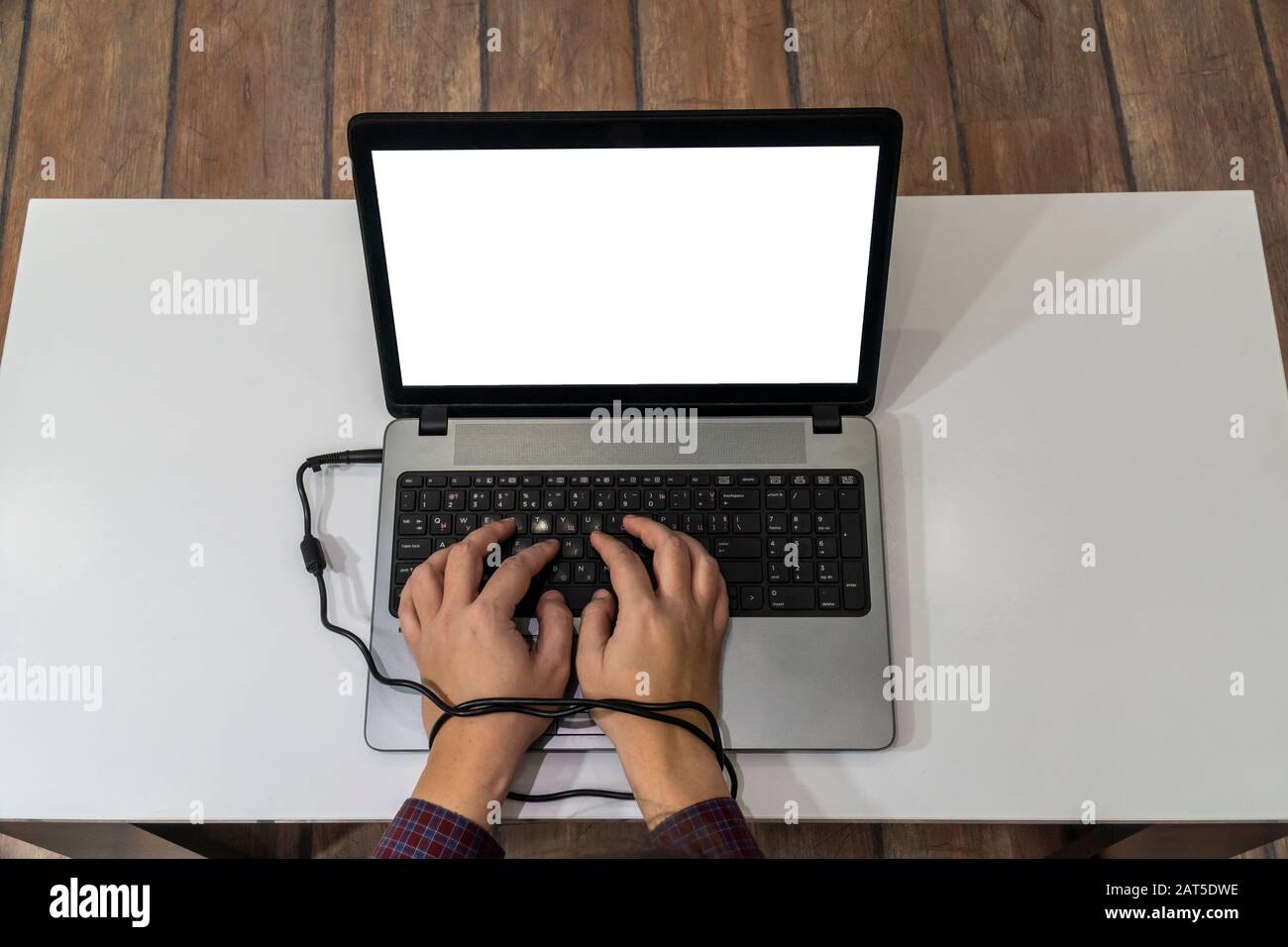 Modern slavery concept. Above view of a man hands typing on a laptop ...