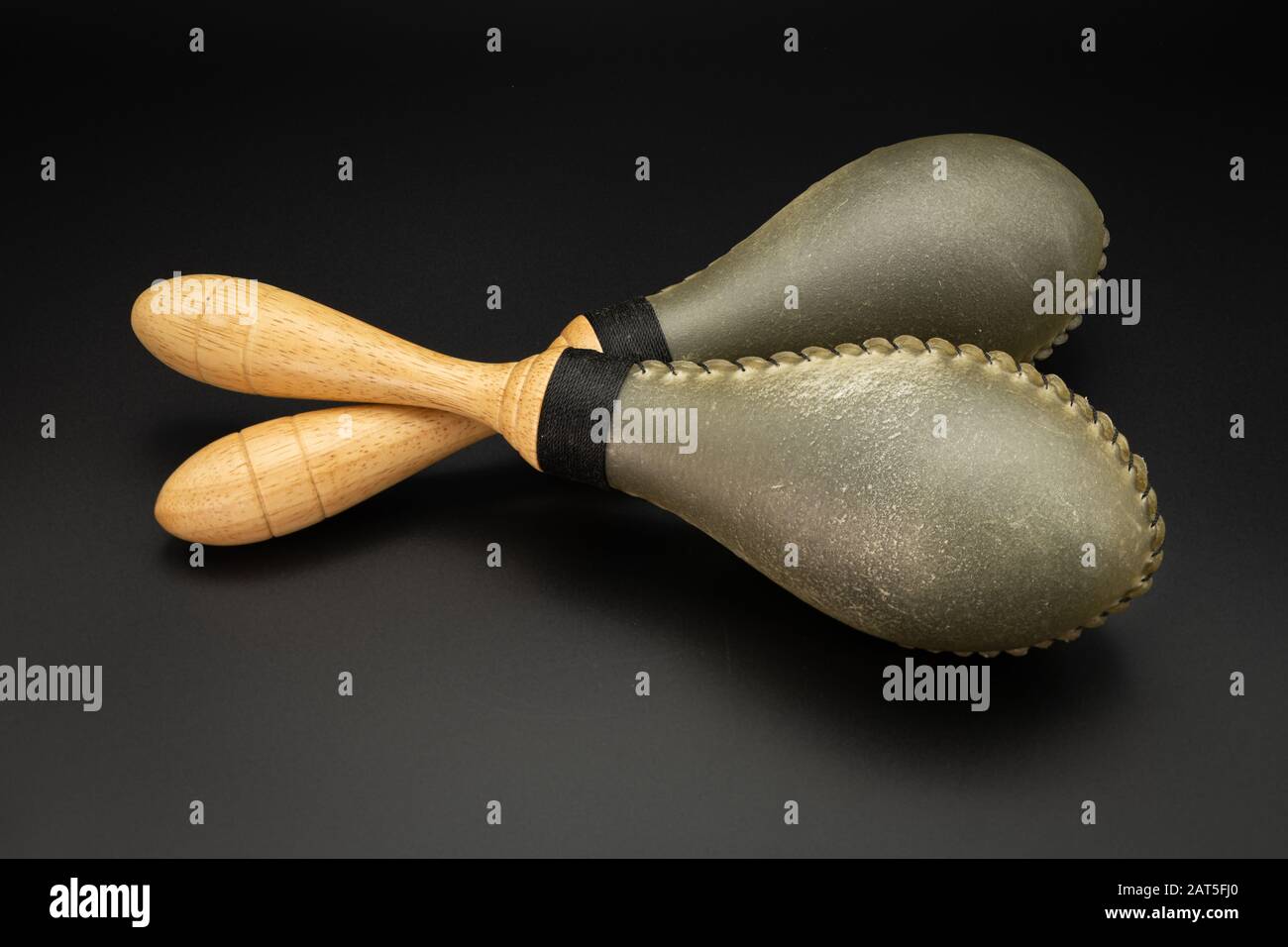 Closeup of a pair of rawhide maracas lying on a black underground Stock ...
