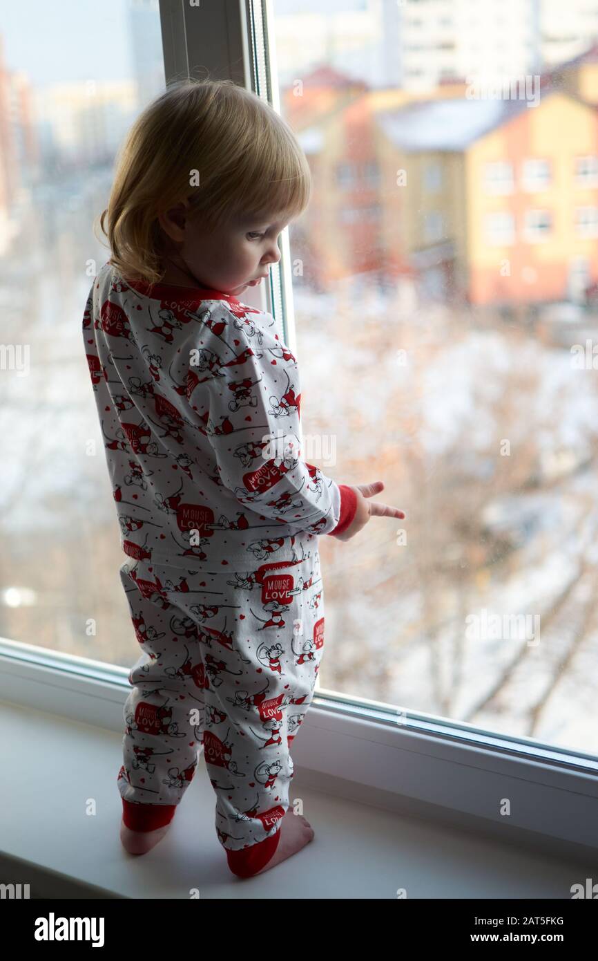 A little girl standing in front of a window Stock Photo - Alamy