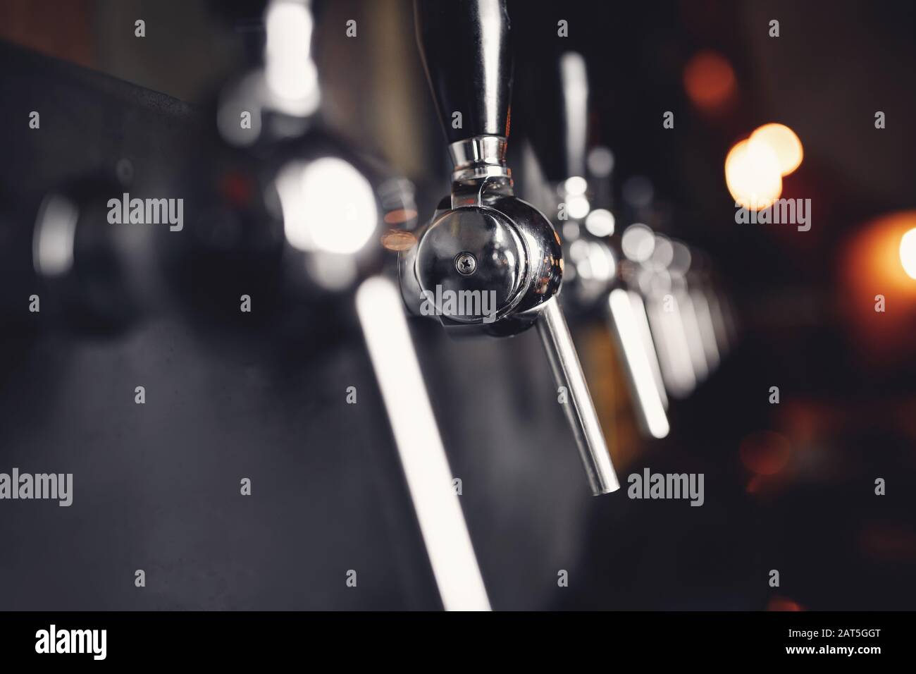 Beer craft steel taps raw in pub. Selective focus, dark background ...