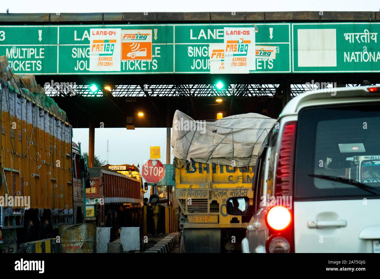 Vehicles, cars, trucks queue at a toll booth in India for cash or ...