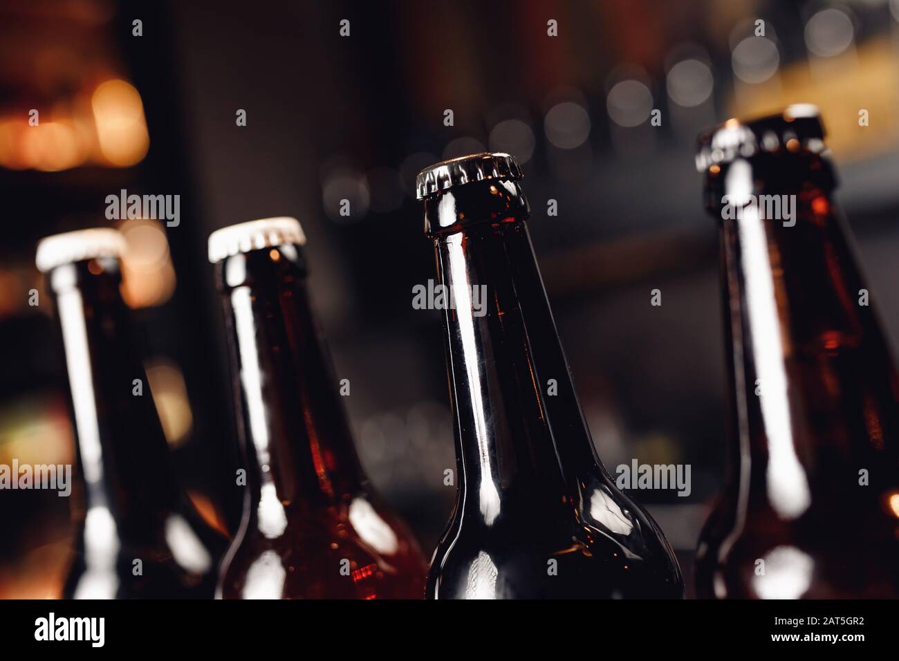Glass bottles of beer on dark pub background Stock Photo - Alamy