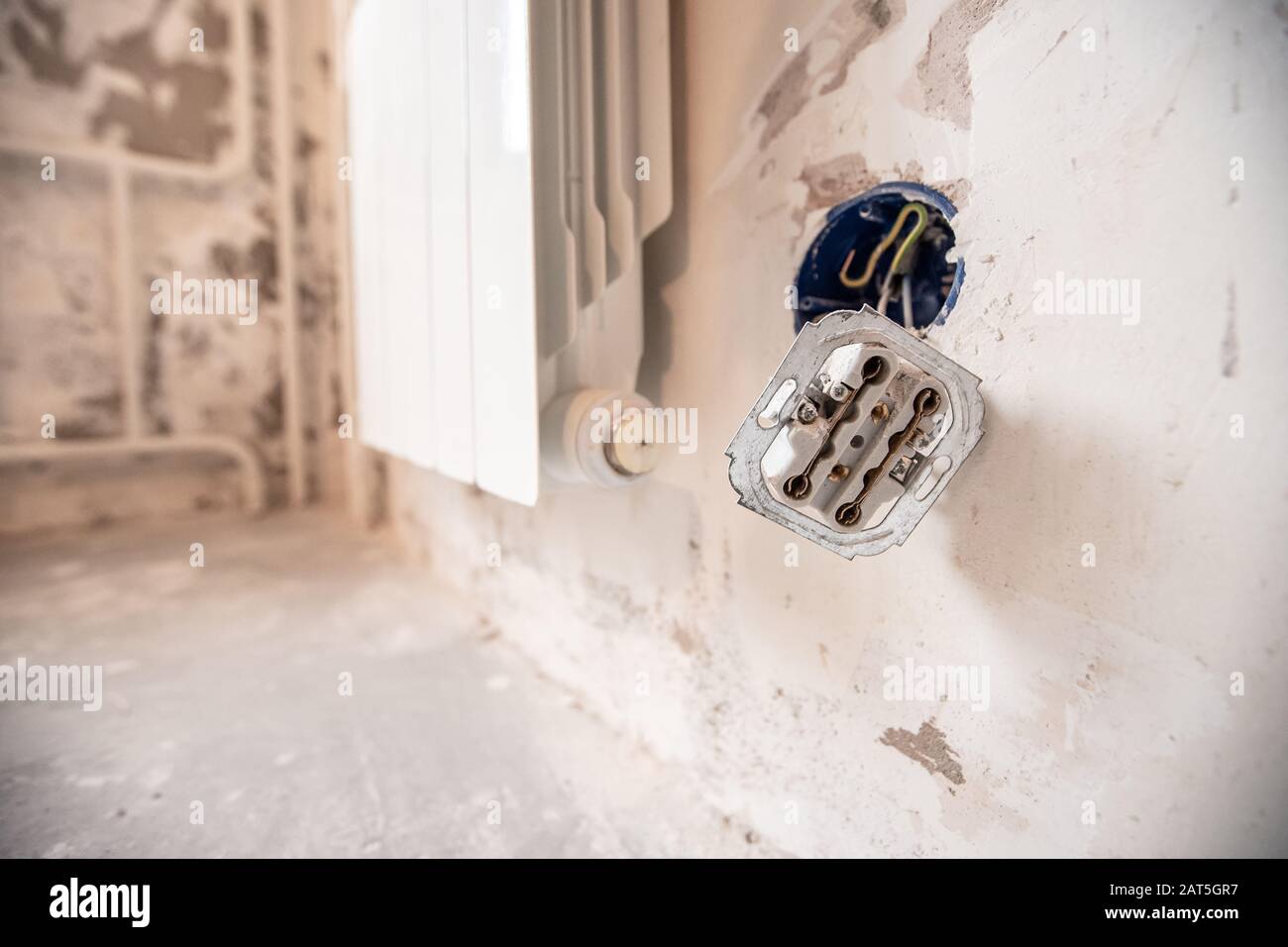 Disassembled electrical outlet in detonation wall with bare wires and ...