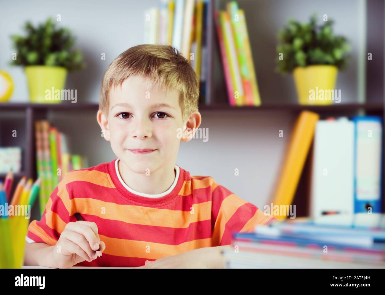 Elementary school boy at classroom desk making schoolwork Stock Photo ...