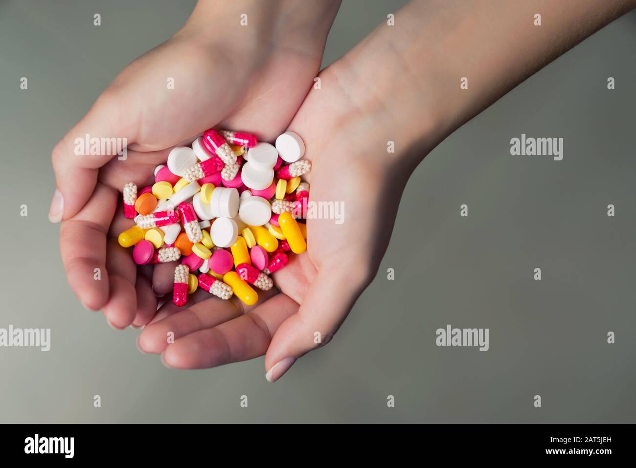 a handful of tablets of different colors in female hands Stock Photo ...