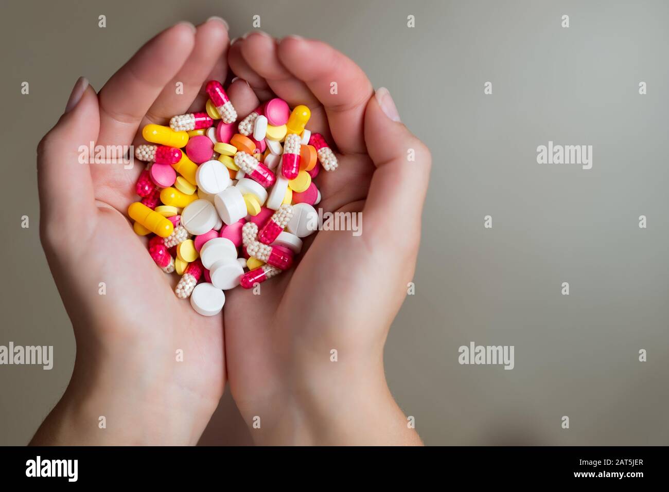 a handful of tablets of different colors in female hands Stock Photo ...