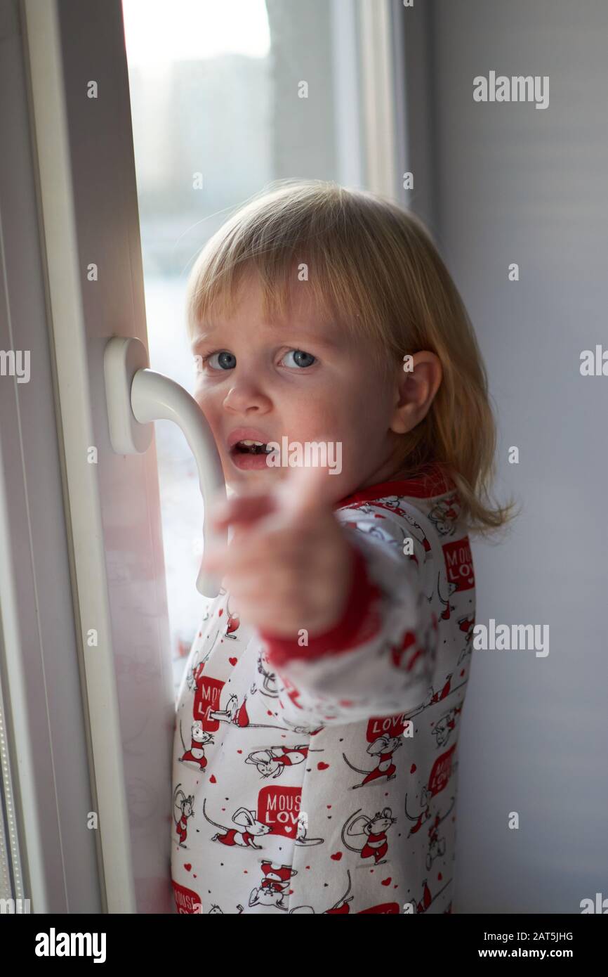 A little girl standing in front of a window Stock Photo - Alamy