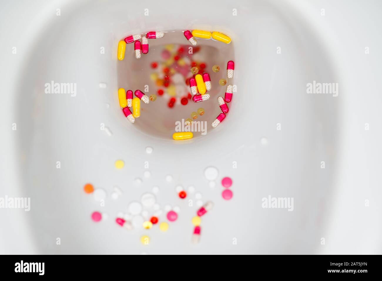 many colored tablets flushed into the toilet. Some dissolved in water ...
