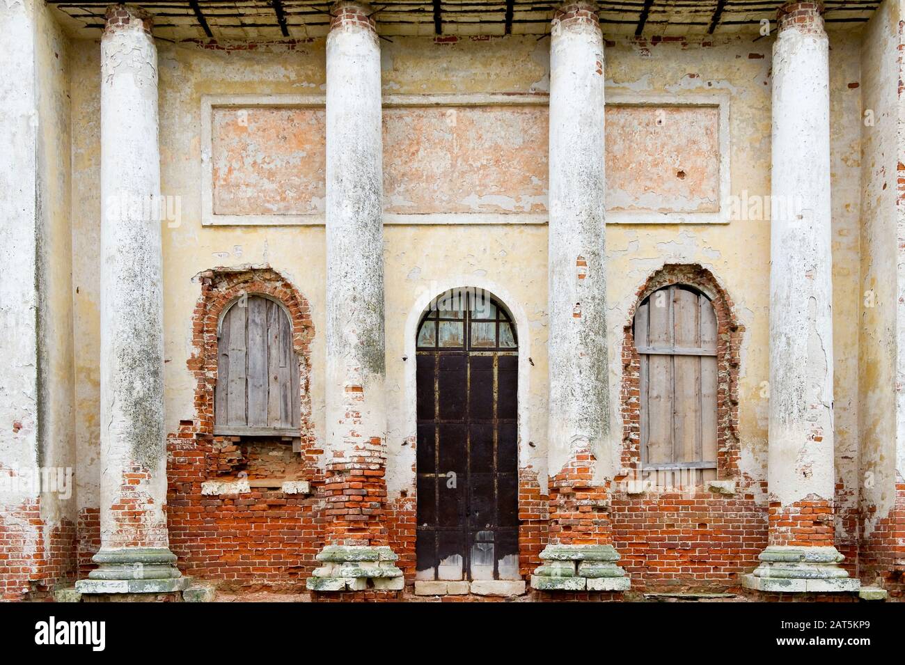 facade of an ancient building with boarded up windows, doors and ...