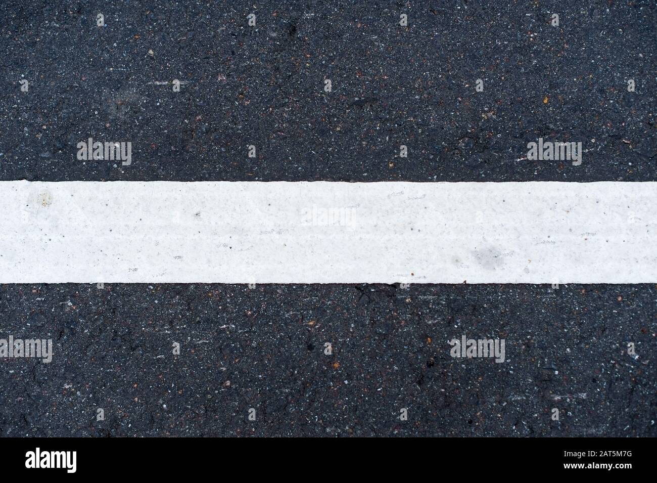 white horizontal road marking line on asphalt in the center of the ...