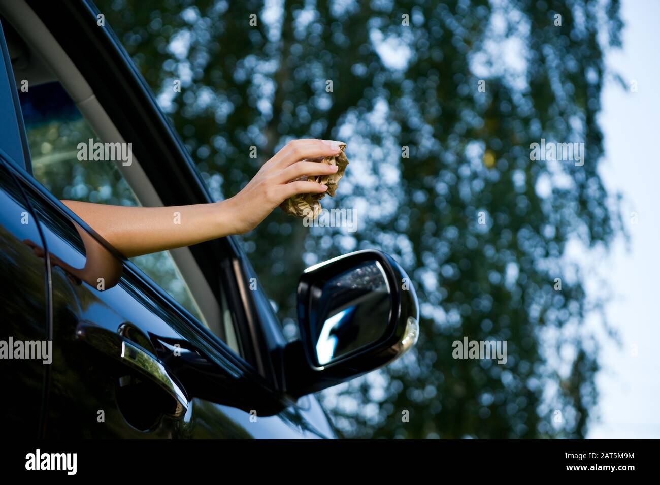 A young woman is about to throw a crumpled piece of paper or packaging ...