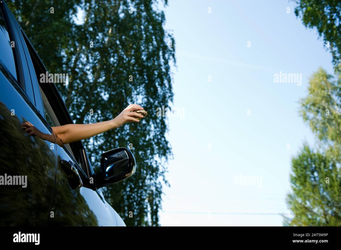 A young woman is about to throw a crumpled piece of paper or packaging ...