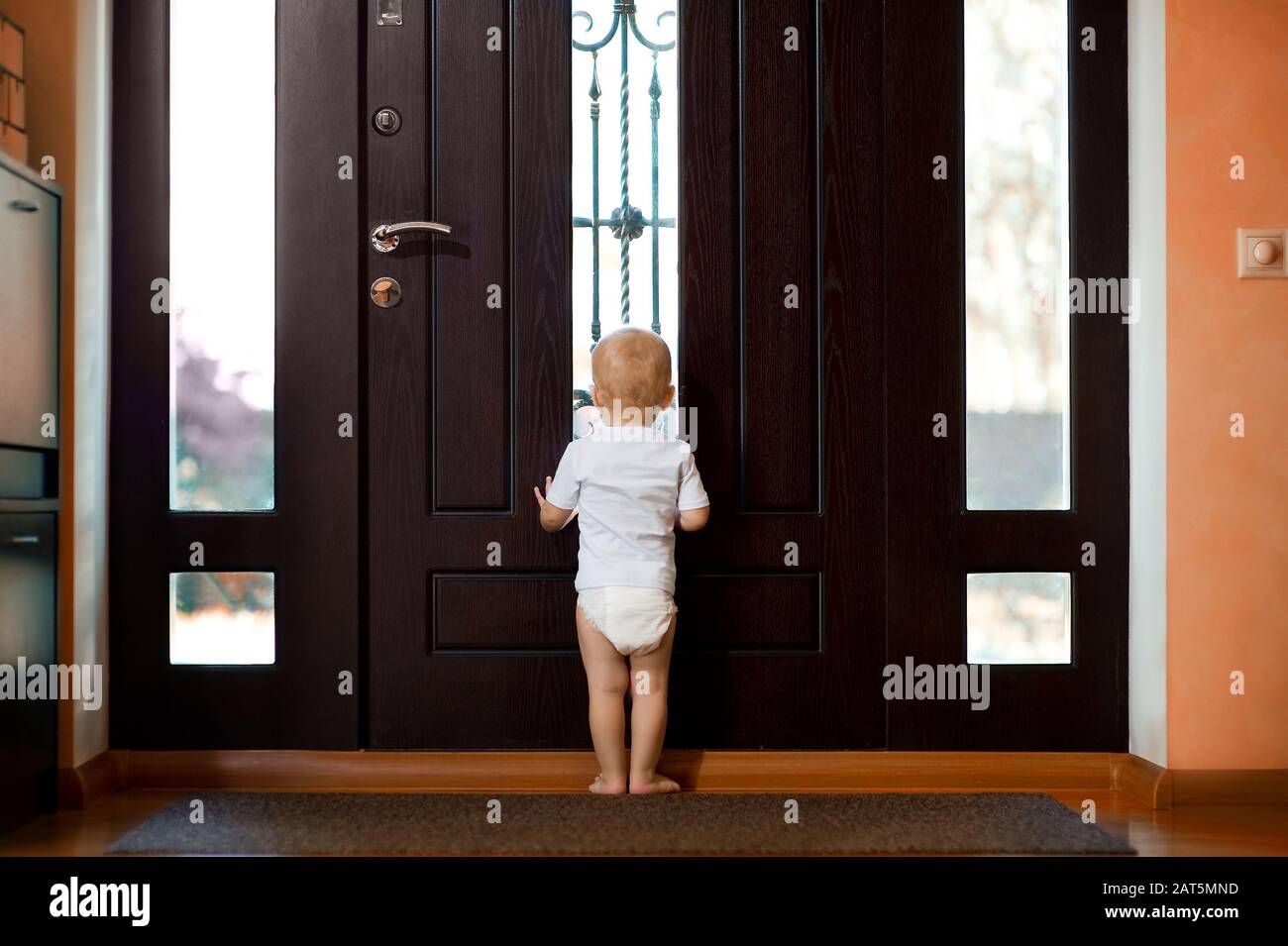 little girl waiting near the front door of mom and dad. Back view Stock ...