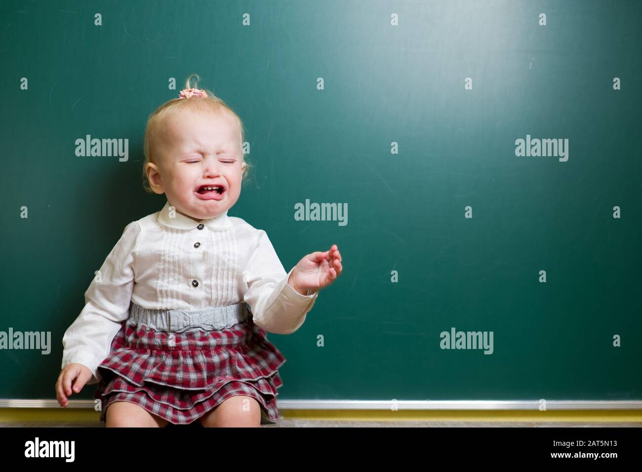 little girl crying near a school blackboard. Crying baby on blackboard ...