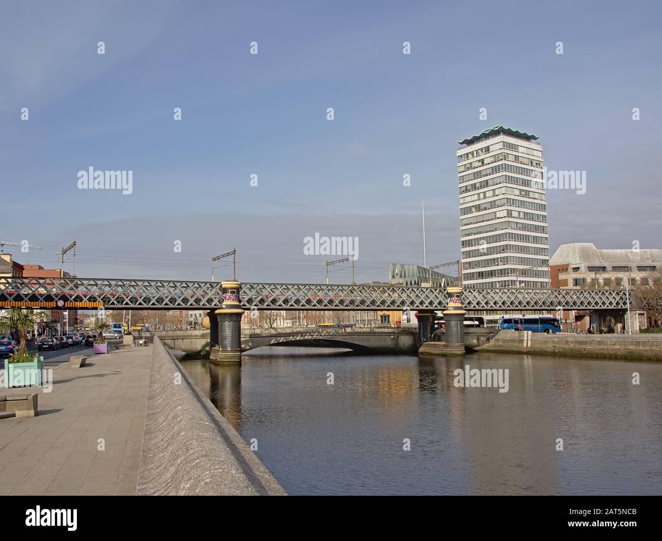 Liffey river, with railway bridge and apartmet skyscraper on the ...
