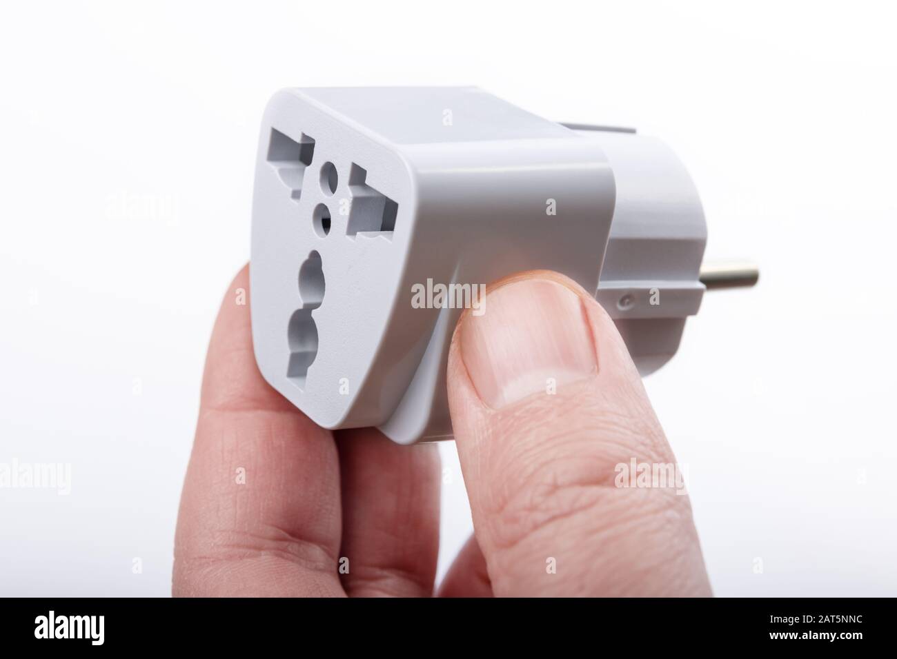 Man`s hands holding Close up Asia-EU adapter plug on white background ...