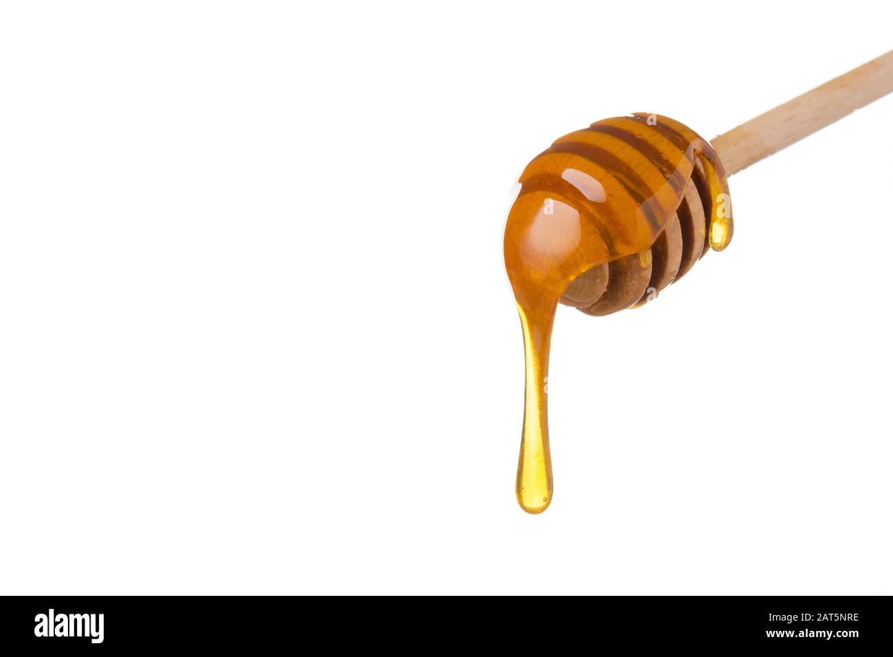 Honey dripping from wooden honey spoon Stock Photo - Alamy