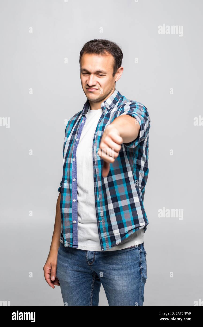 young man making the thumbs down negative hand sign on white background ...