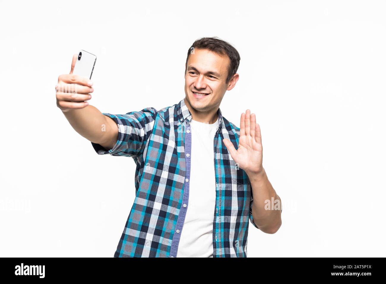 Cheerful handsome man taking selfie and waving hello to the front ...