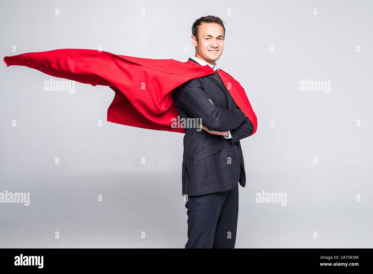 A businessman in a hero red cape and a mask in front view looking in ...