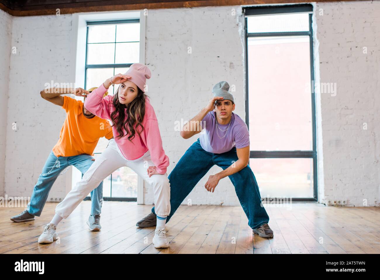 stylish girl breakdancing with multicultural men in hats Stock Photo ...