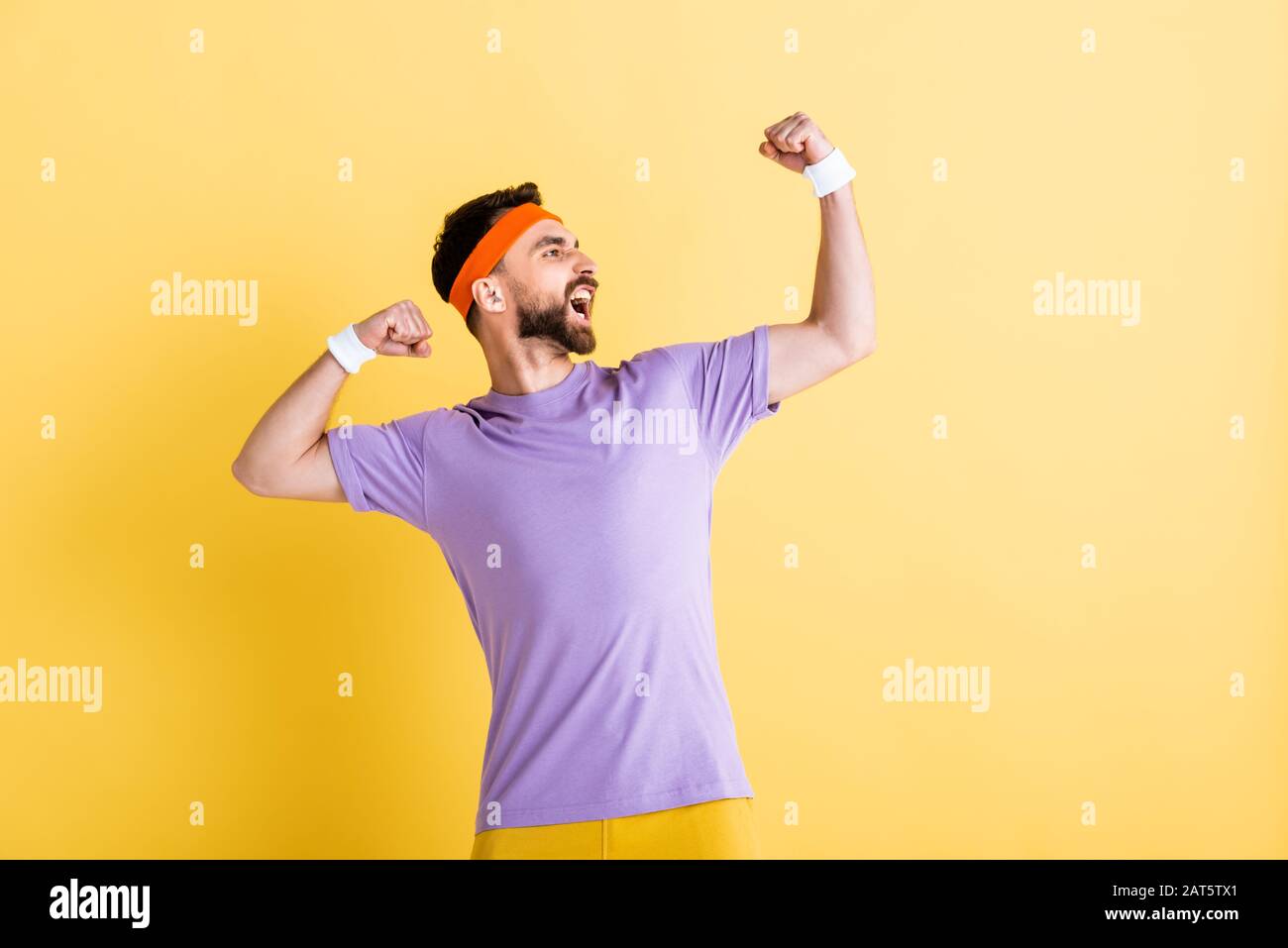 happy winner in headband screaming while celebrating on yellow Stock ...