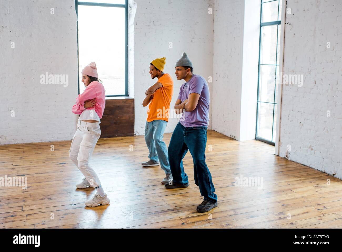 stylish girl with crossed arms breakdancing with handsome multicultural ...