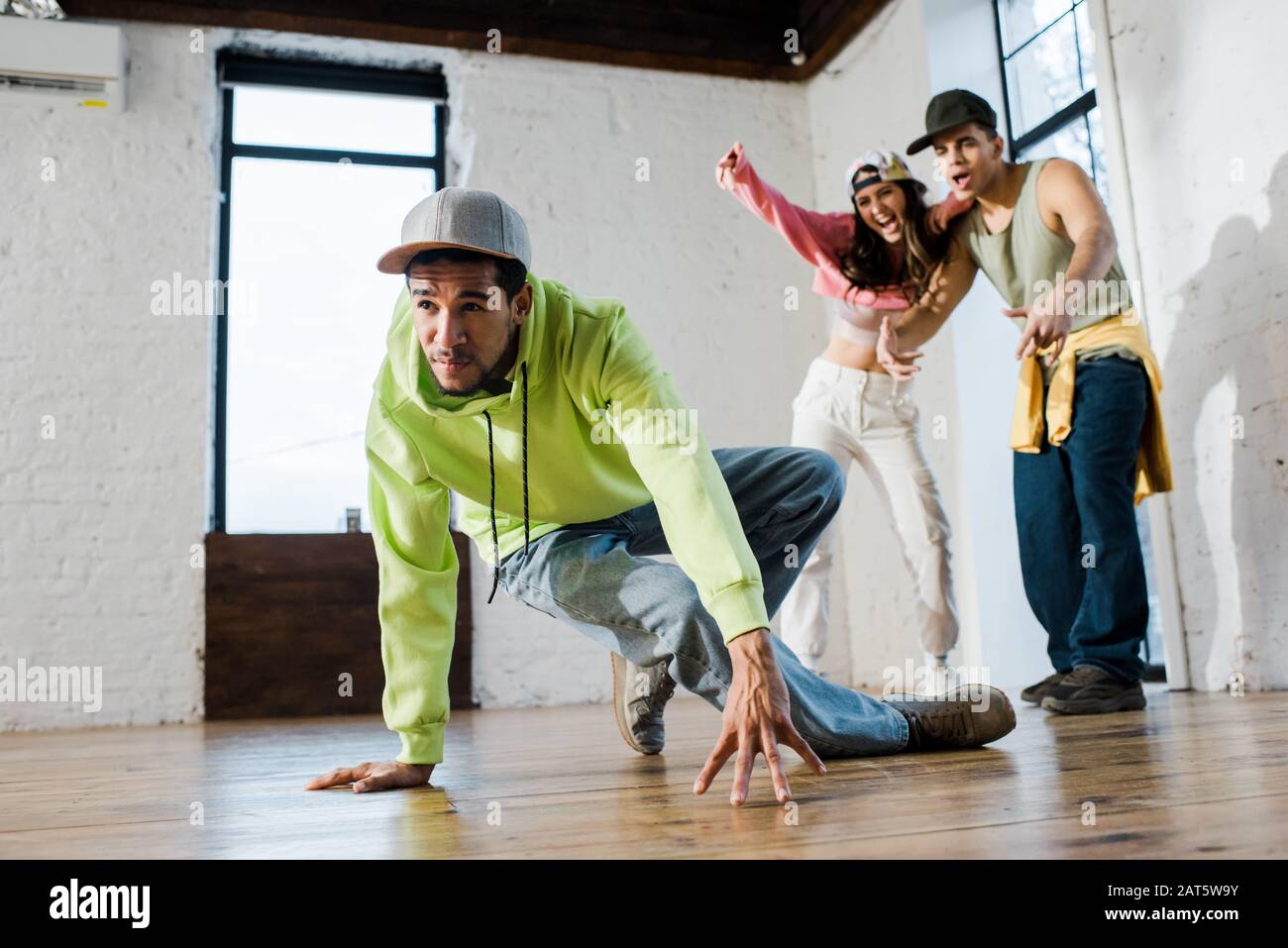 selective focus of handsome african american dancer breakdancing near ...