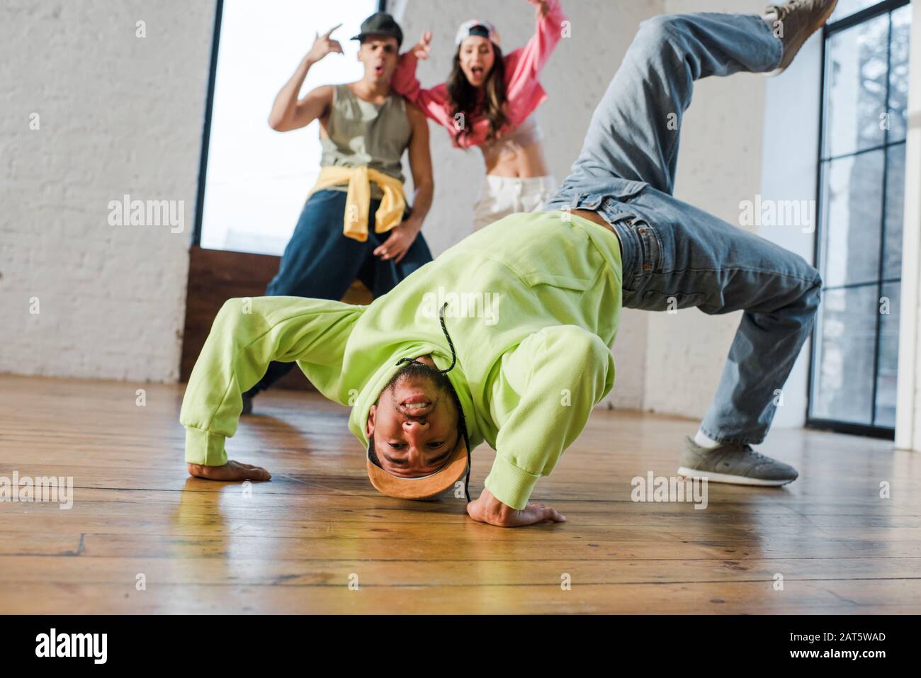 selective focus of african american man breakdancing near emotional ...