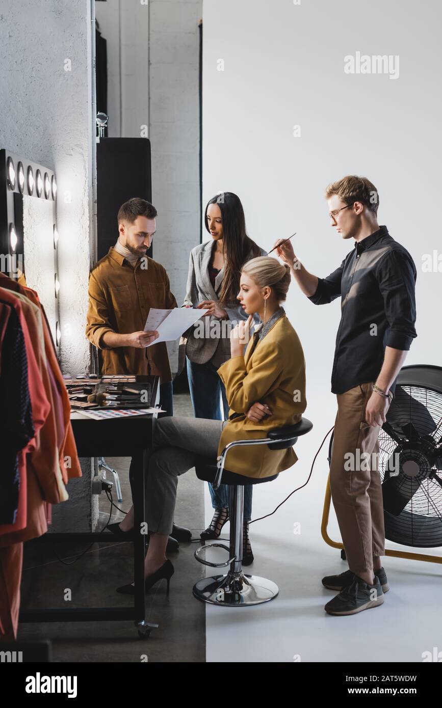 producer and photographer talking and hairstylist doing hairstyle to ...