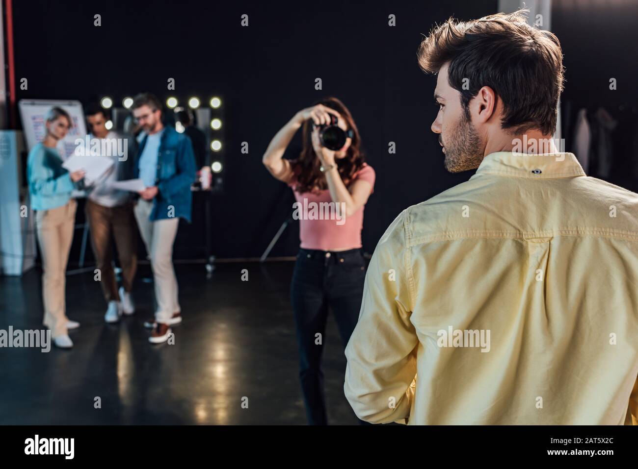 selective focus of photographer taking photo of bearded man near art ...