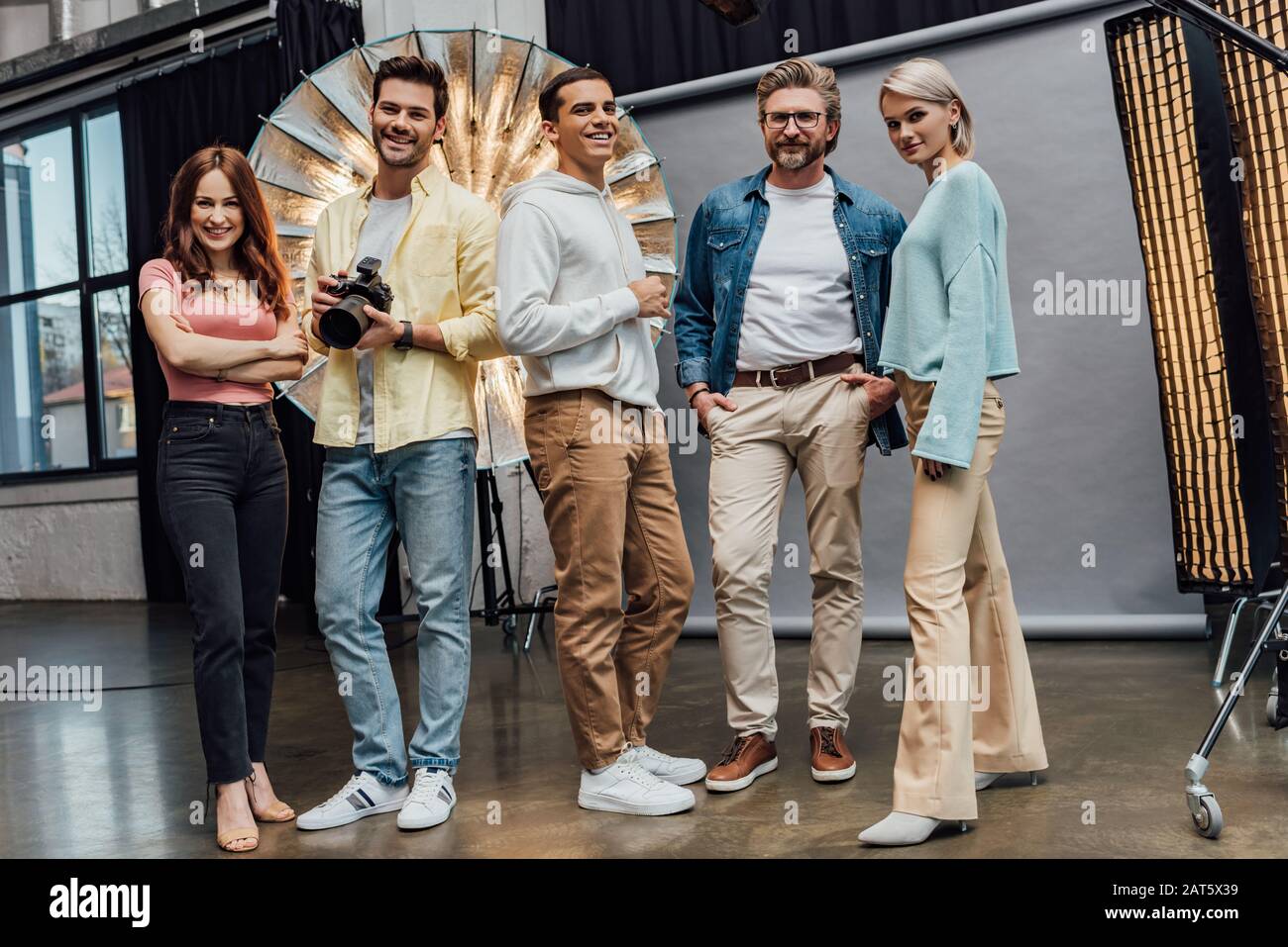 positive team smiling while looking at camera in photo studio Stock ...
