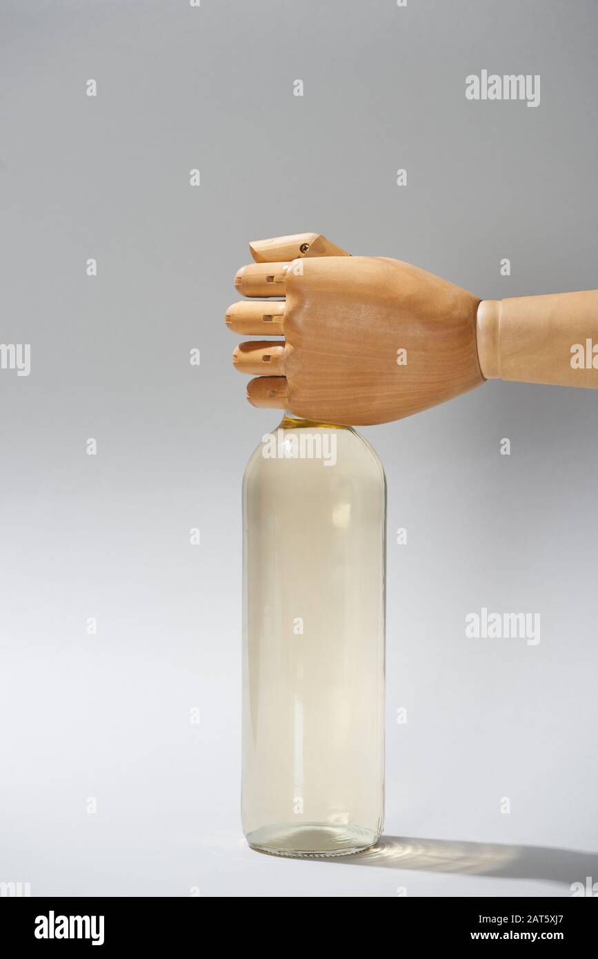 Wooden hand of dummy with bottle of wine on grey background Stock Photo ...