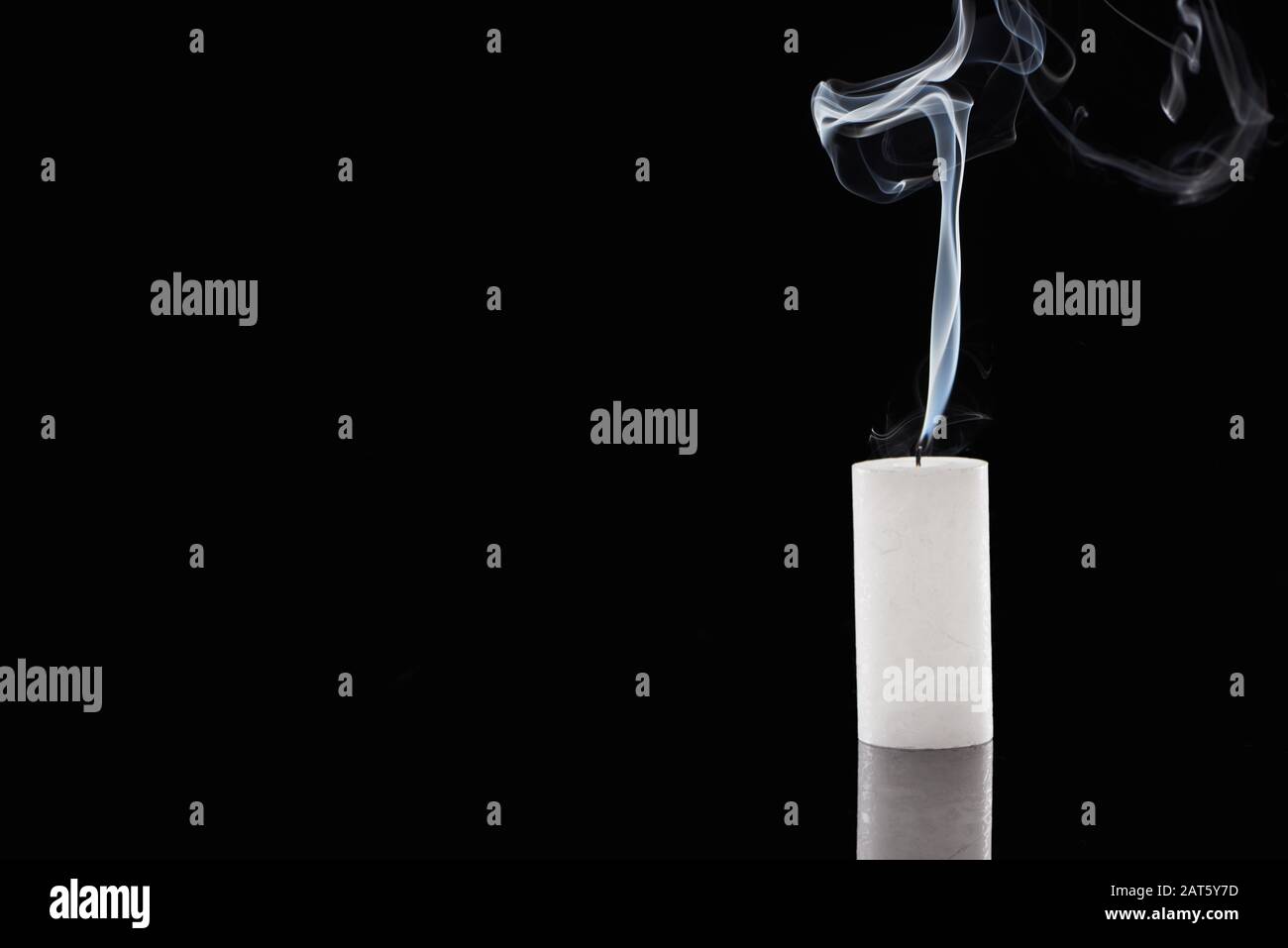 extinct white candle with smoke on black background Stock Photo - Alamy