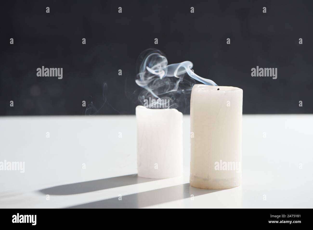 extinct white candles with smoke on black background Stock Photo - Alamy